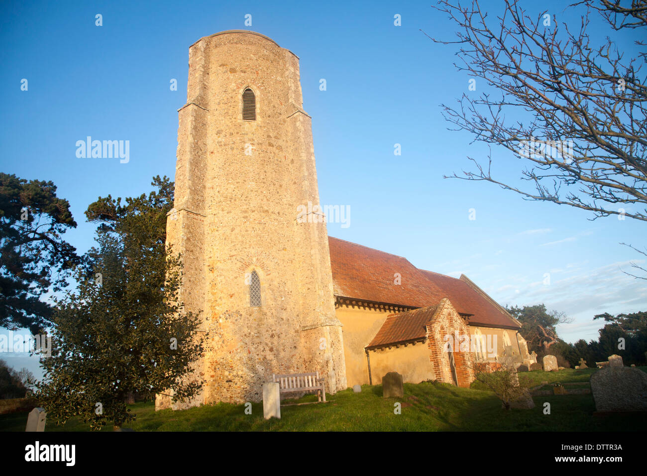Historic round tower set against deep blue sky, All Saints church ...