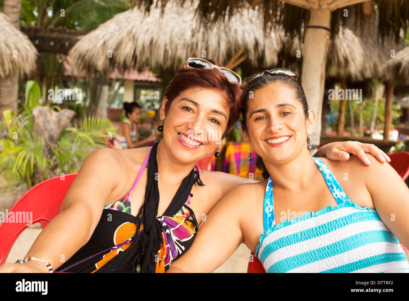 Hispanic women smiling at resort Stock Photo - Alamy