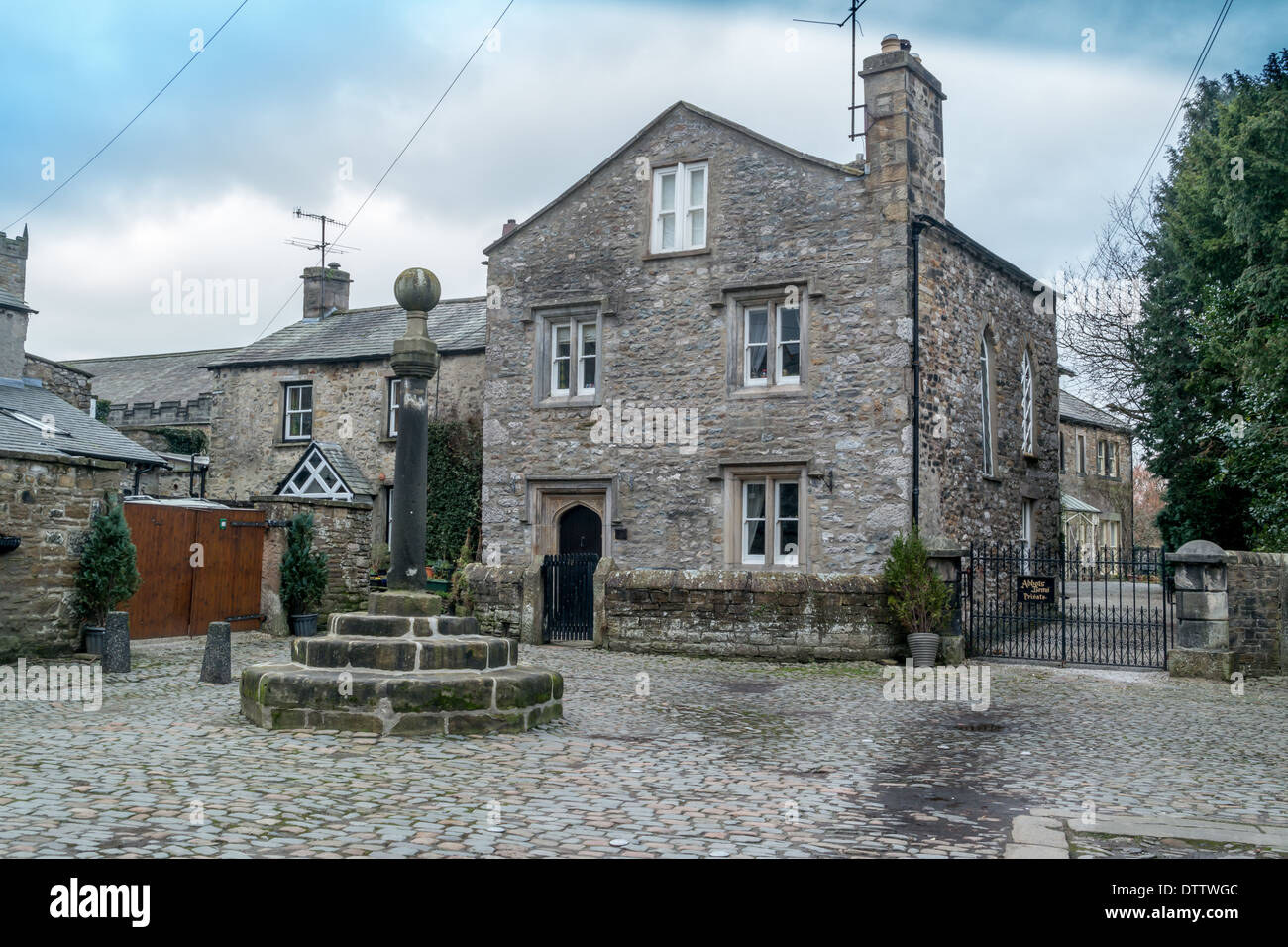 Large old stone built house with a cobbled square and a stone monument ...
