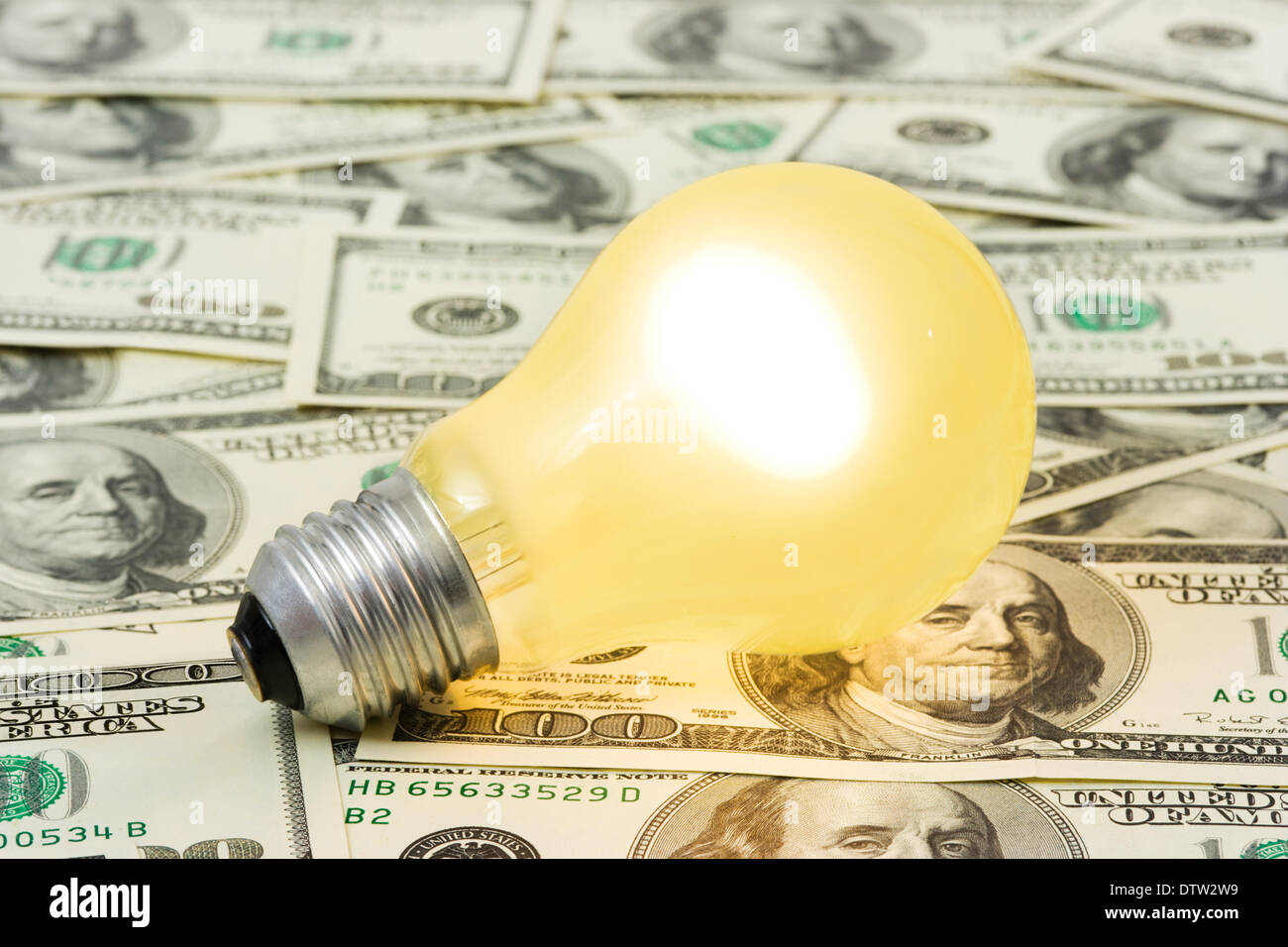 Lighting lamp on money background Stock Photo - Alamy