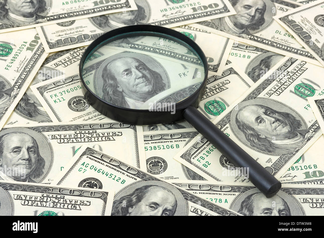 Magnifying glass on money background Stock Photo - Alamy