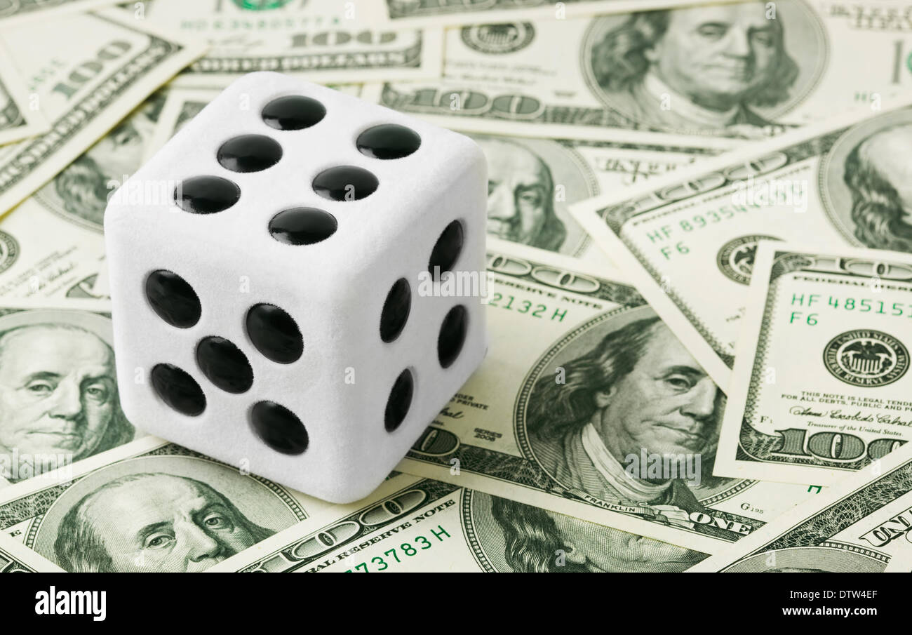 Dice on money background Stock Photo - Alamy