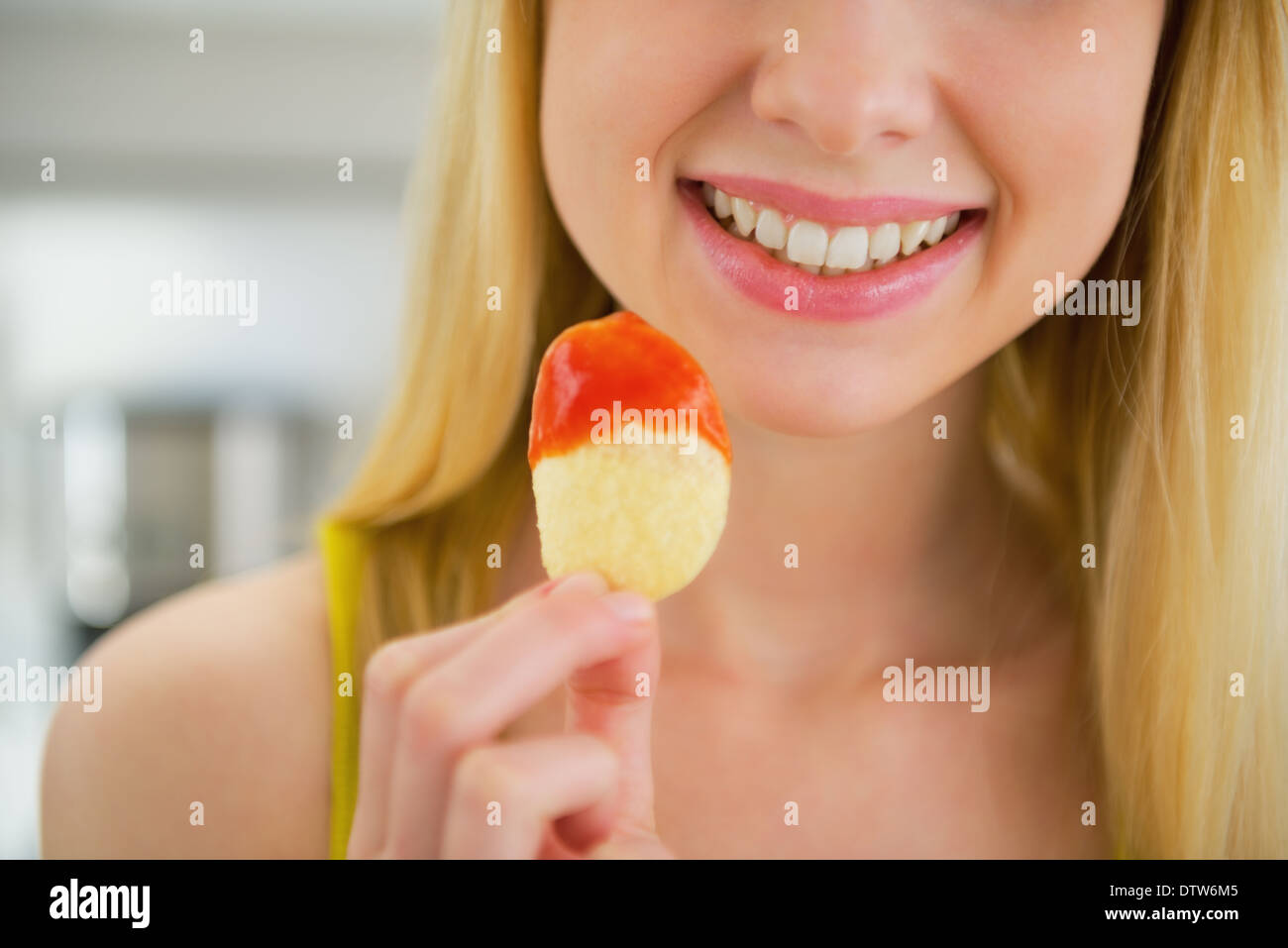 Closeup on young woman eating chips Stock Photo - Alamy
