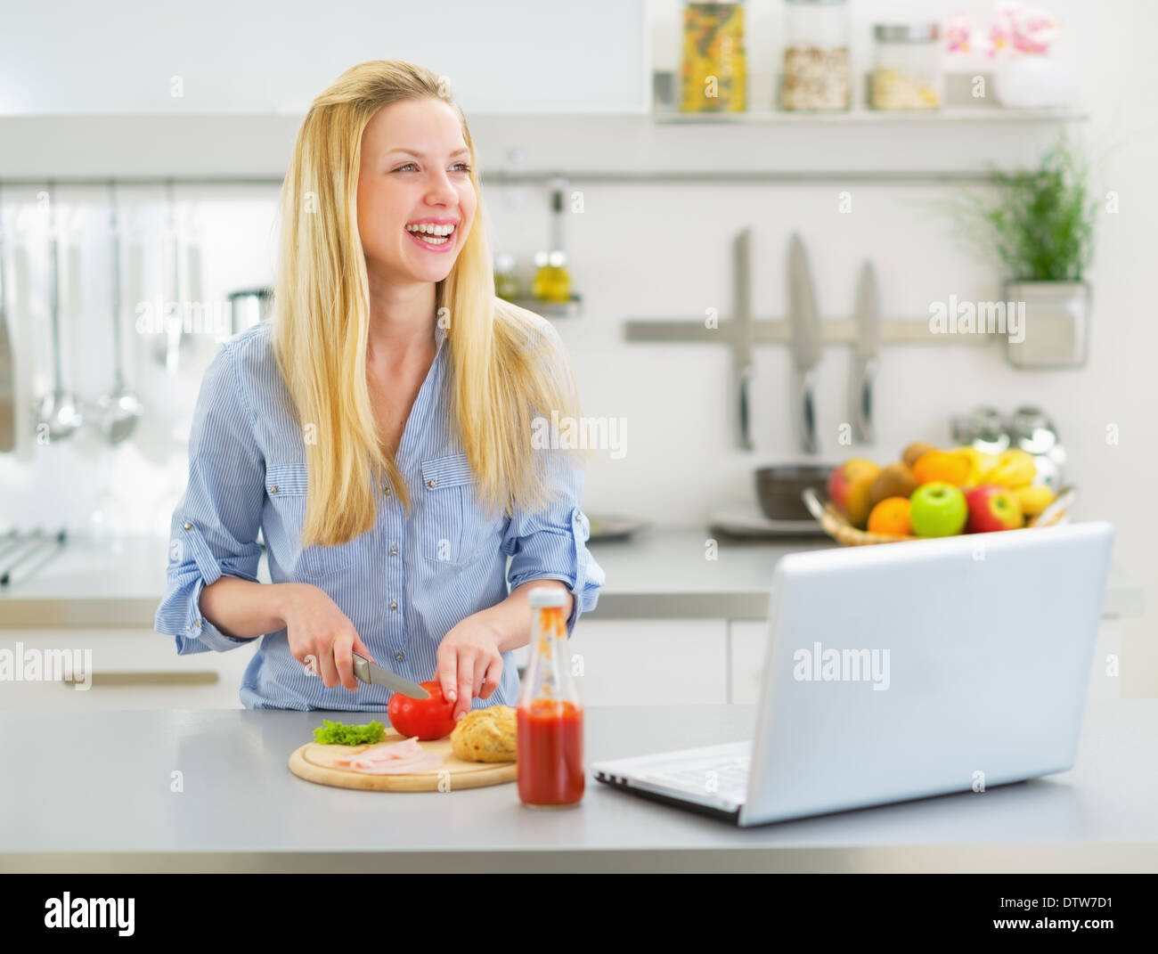 Smiling young woman making snacks in kitchen Stock Photo - Alamy