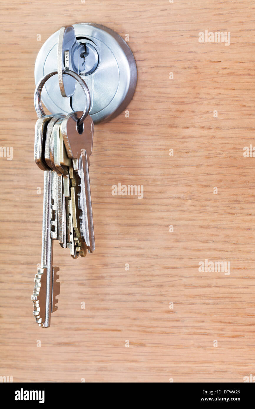 bunch of house keys in lock of wood door close up Stock Photo - Alamy