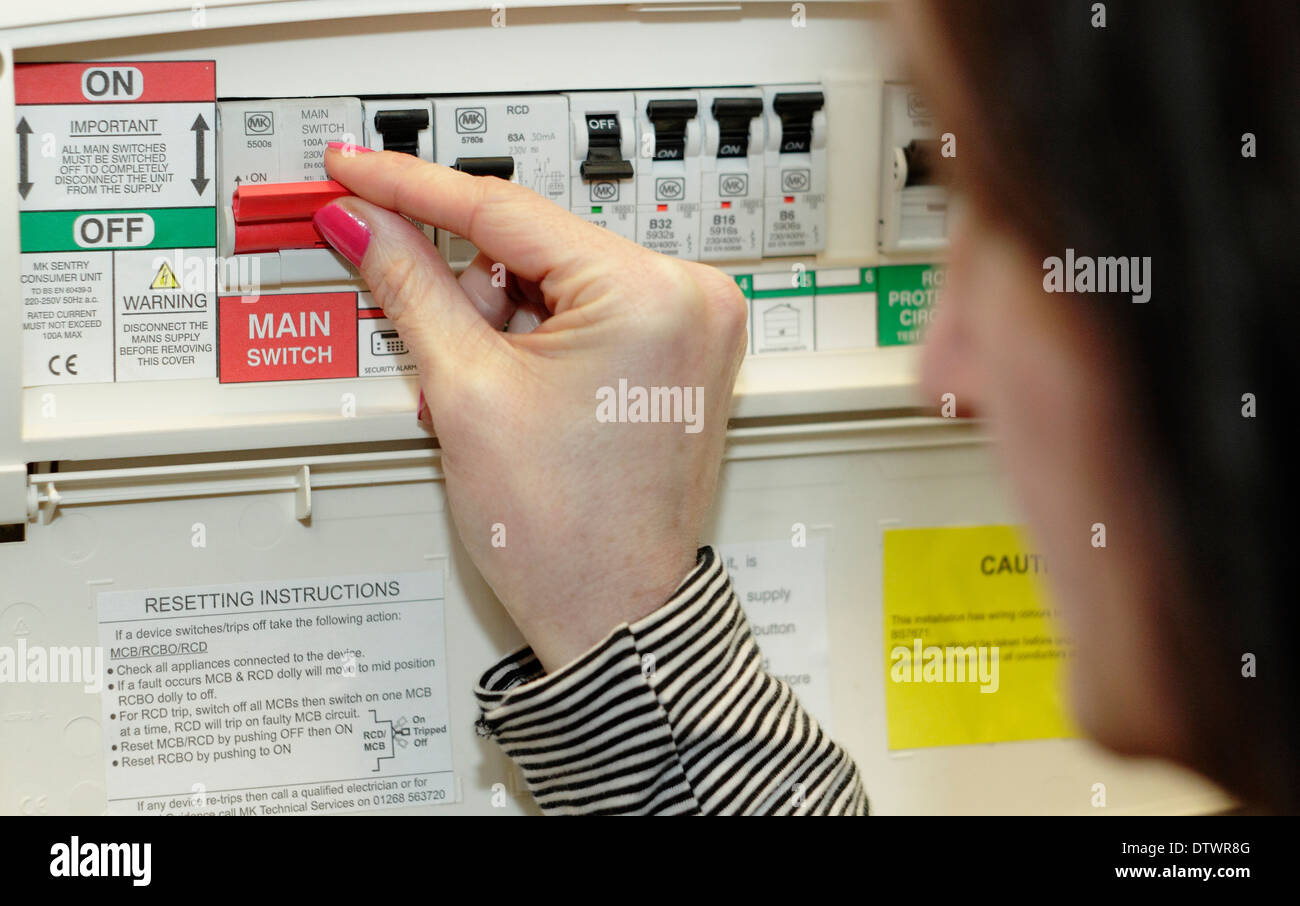 Woman switches trip/residual current device (RCD) / consumer unit in a ...