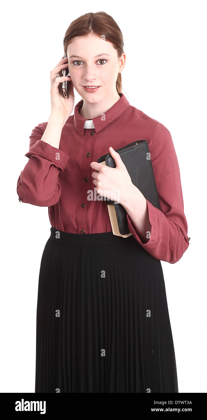 Young girl acting as a lady vicar using her mobile cell phone, November ...