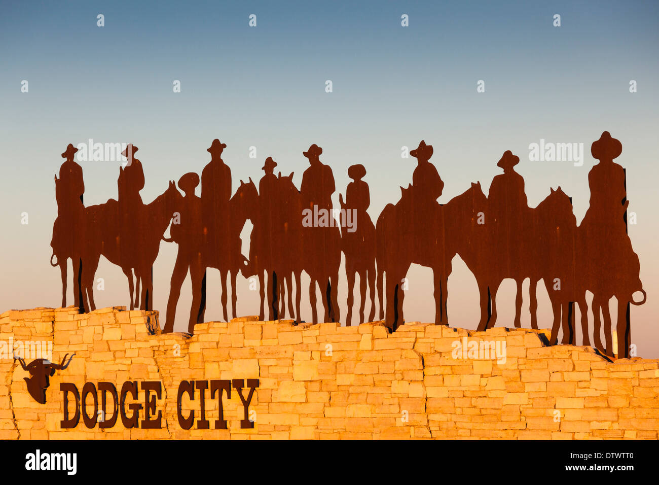 USA, Kansas, Dodge City, city sign with cowboy silhouettes at dawn ...