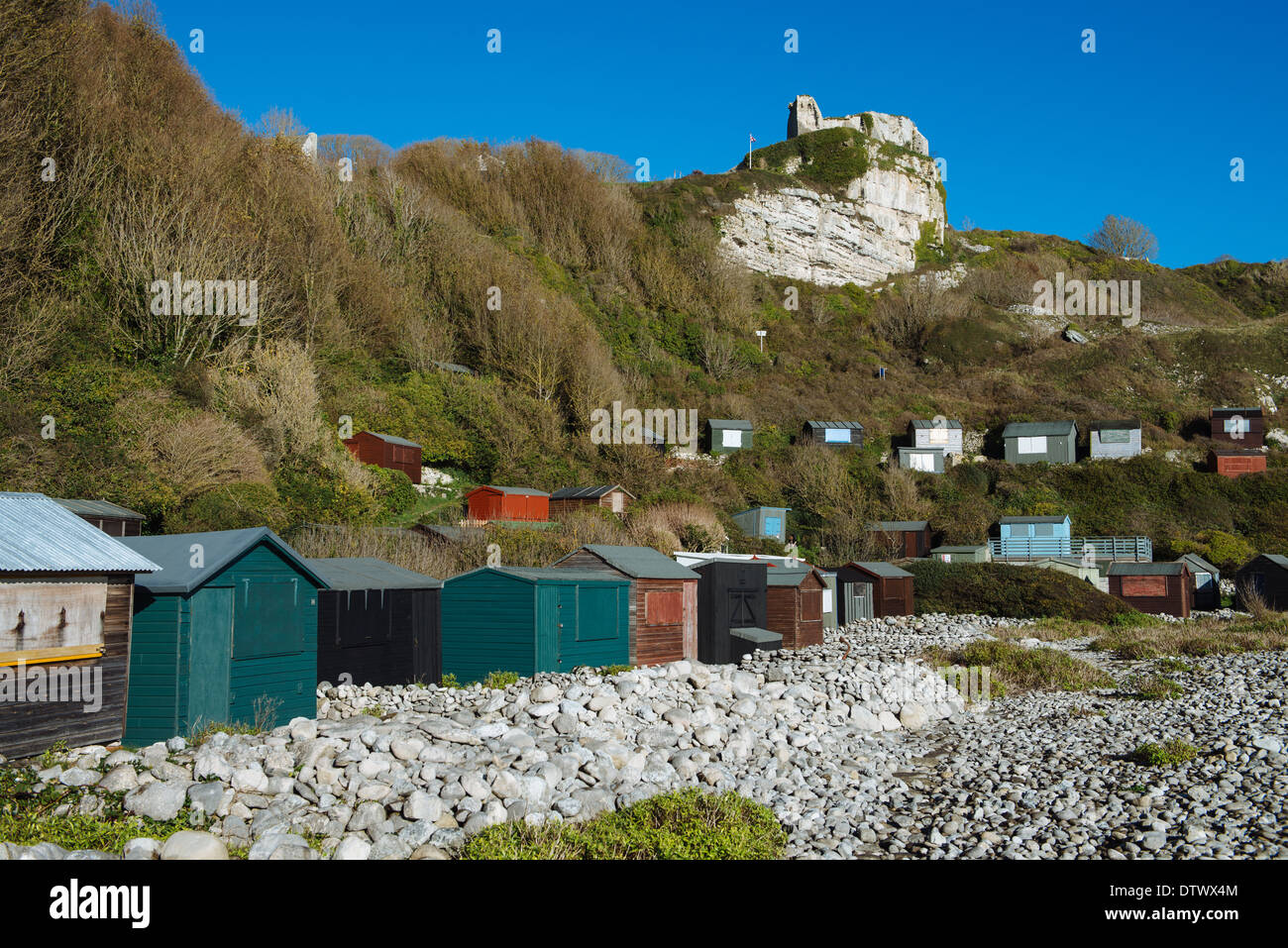 beach huts at Church Ope Cove on the isle of Portland with Rufus Castle ...