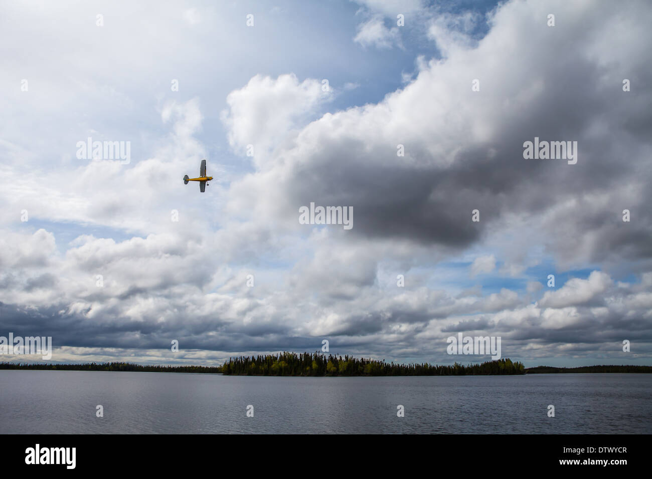 Small float plane flying over a lake in the Kenai Wildlife Refuge in ...