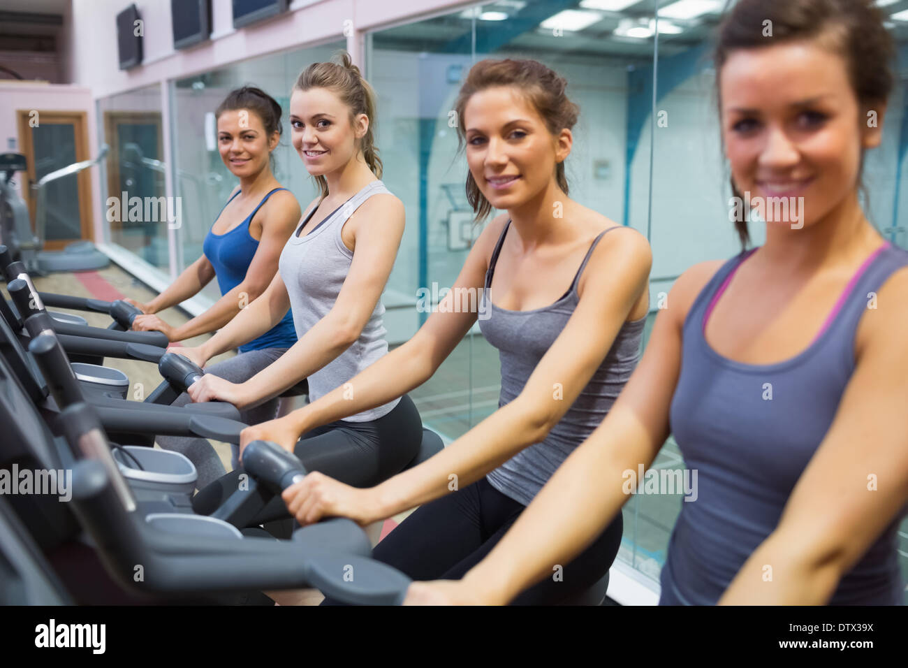 Happy women on exercise bikes Stock Photo - Alamy