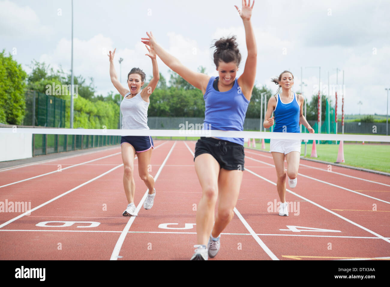 Athlete celebrates race win at finish line Stock Photo - Alamy