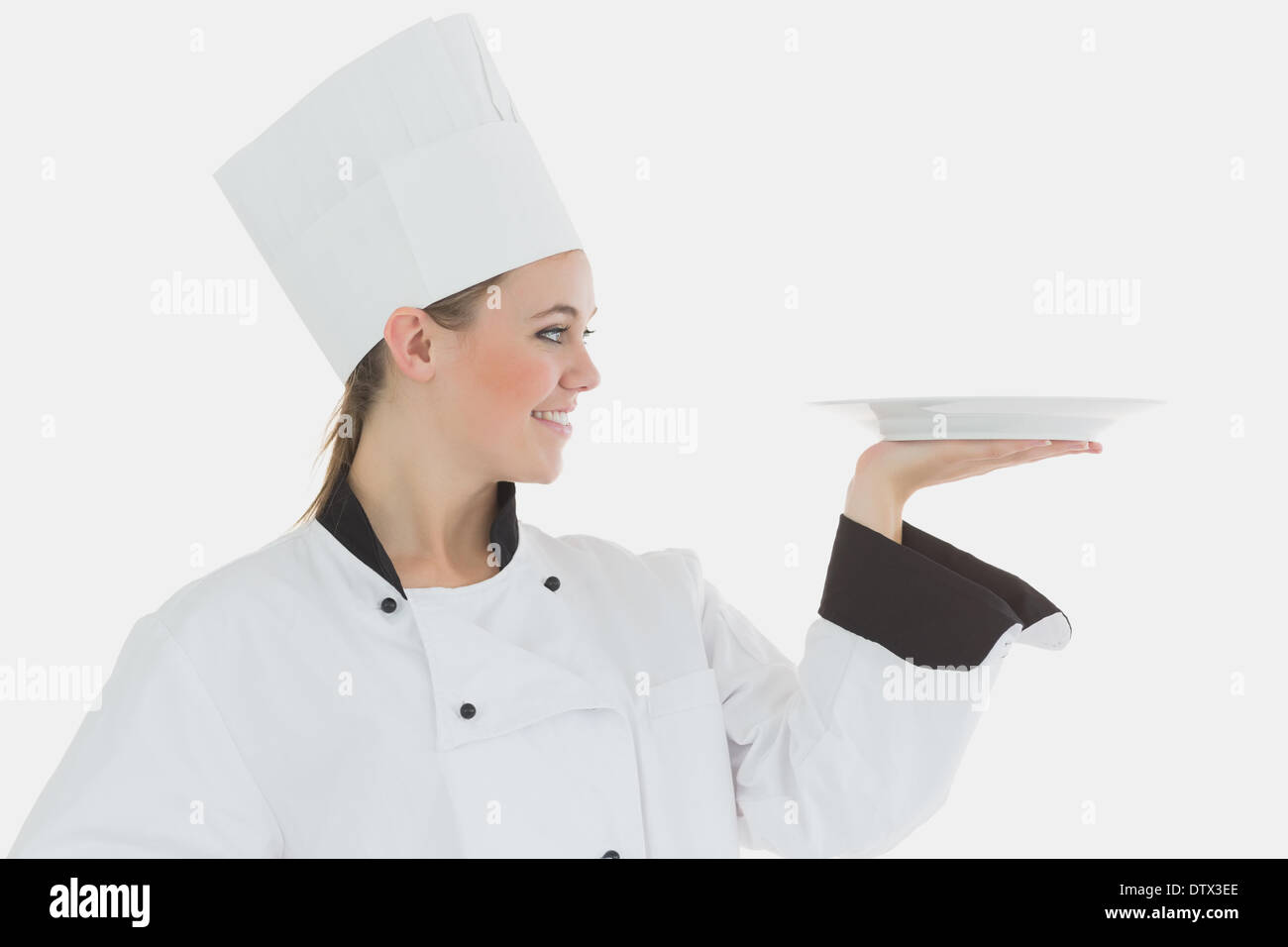 Female chef looking at an empty plate Stock Photo - Alamy