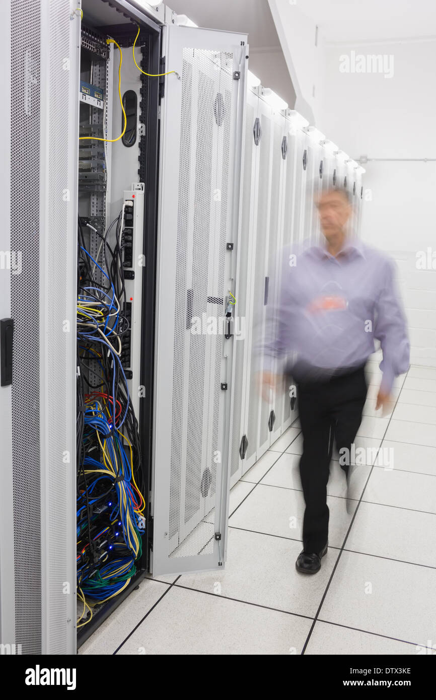Man walking towards open server tower Stock Photo - Alamy