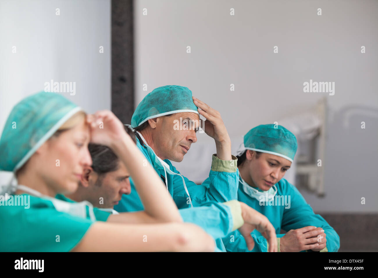 Group of sad surgeons sitting on the floor Stock Photo - Alamy