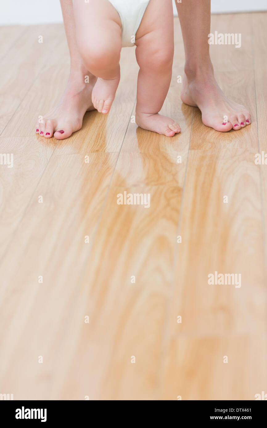 Barefoot mother helping her child to walk Stock Photo - Alamy
