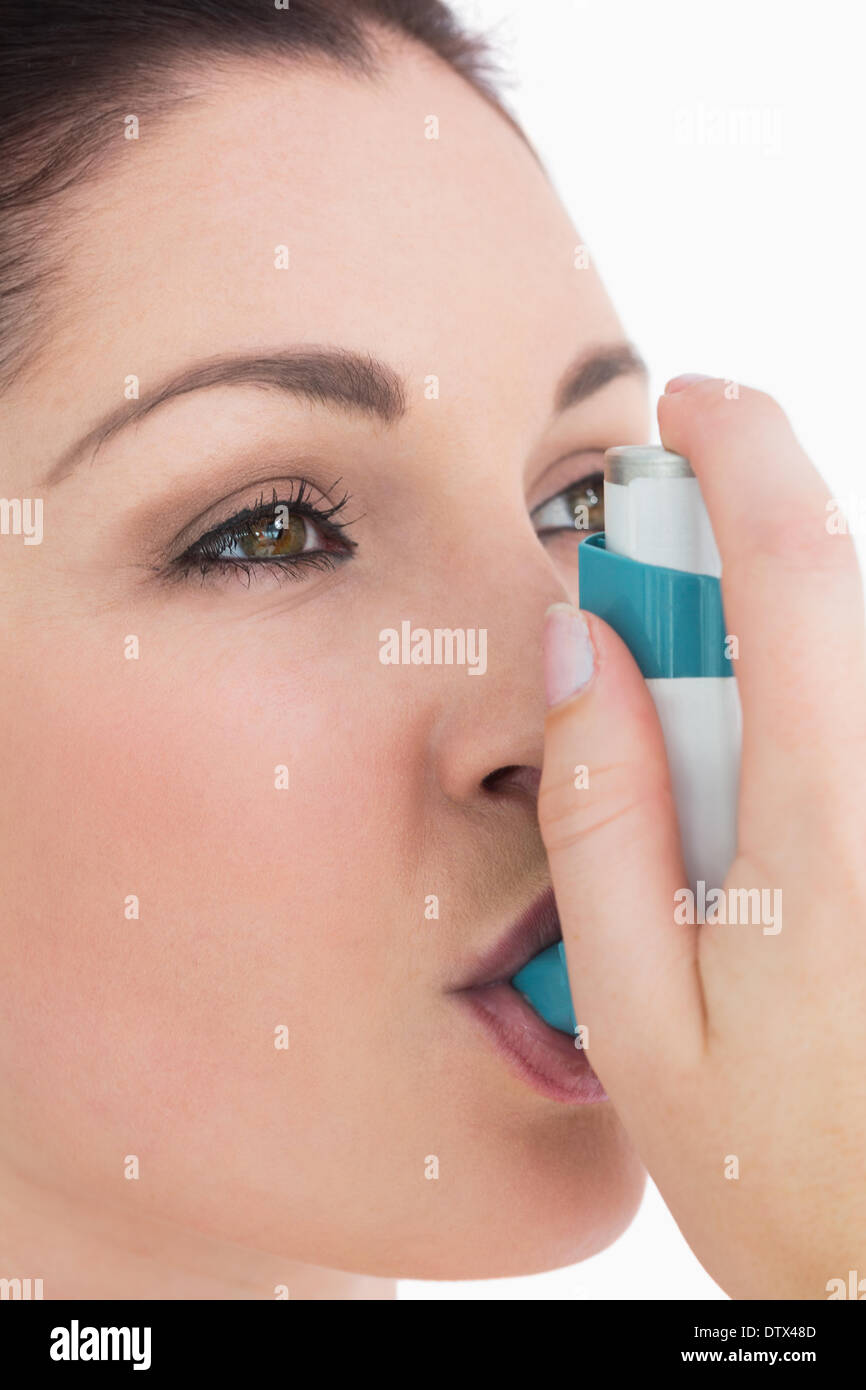 Brunette woman using asthma inhaler Stock Photo - Alamy