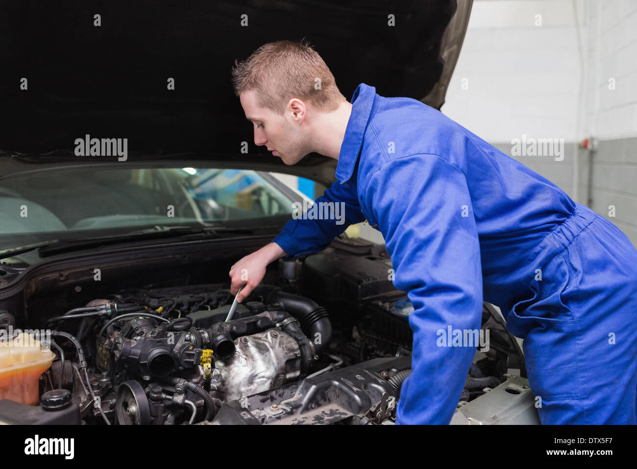 Mechanic working under car bonnet Stock Photo - Alamy