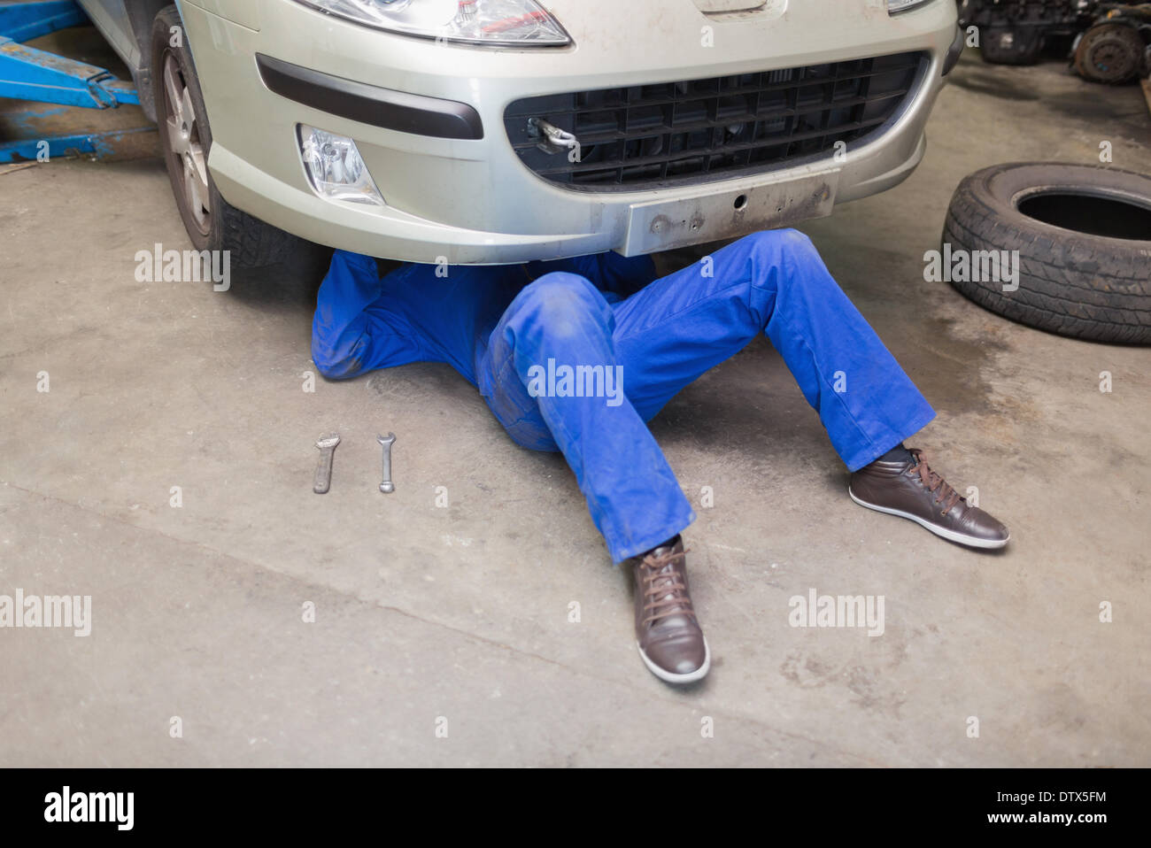 Mechanic working under car Stock Photo - Alamy