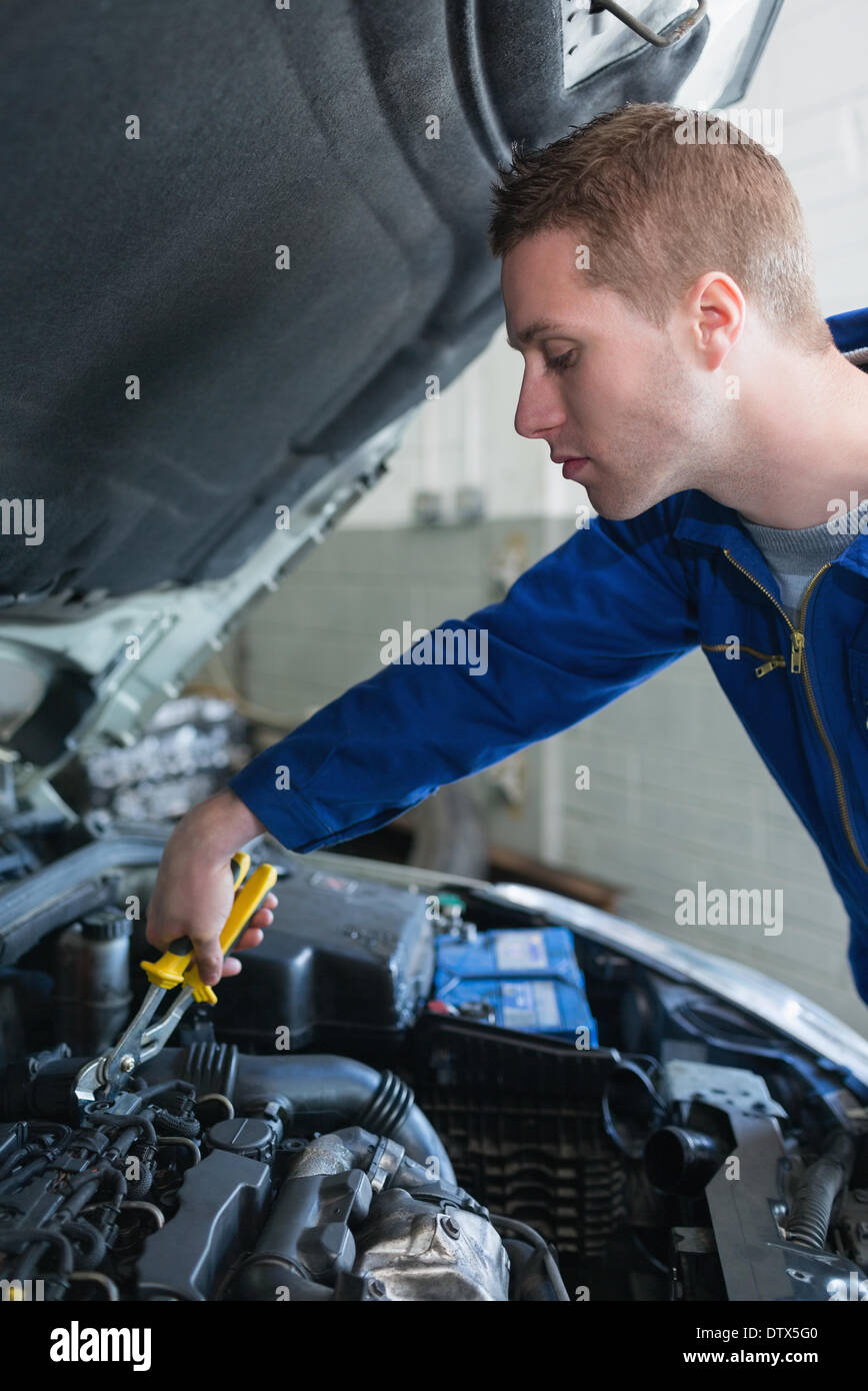 Mechanic working on car engine Stock Photo - Alamy