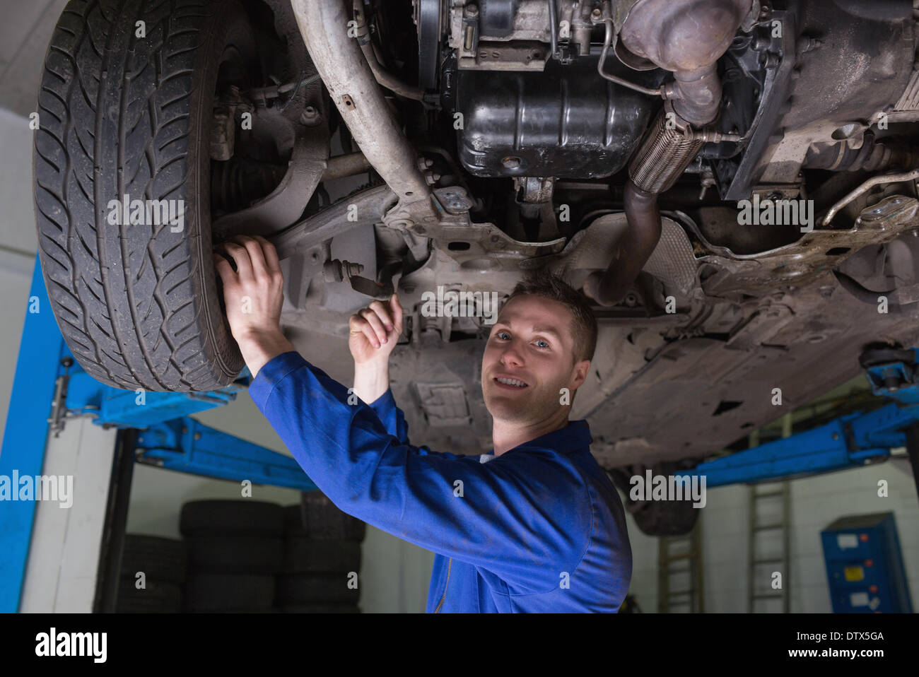 Auto mechanic working under car Stock Photo - Alamy