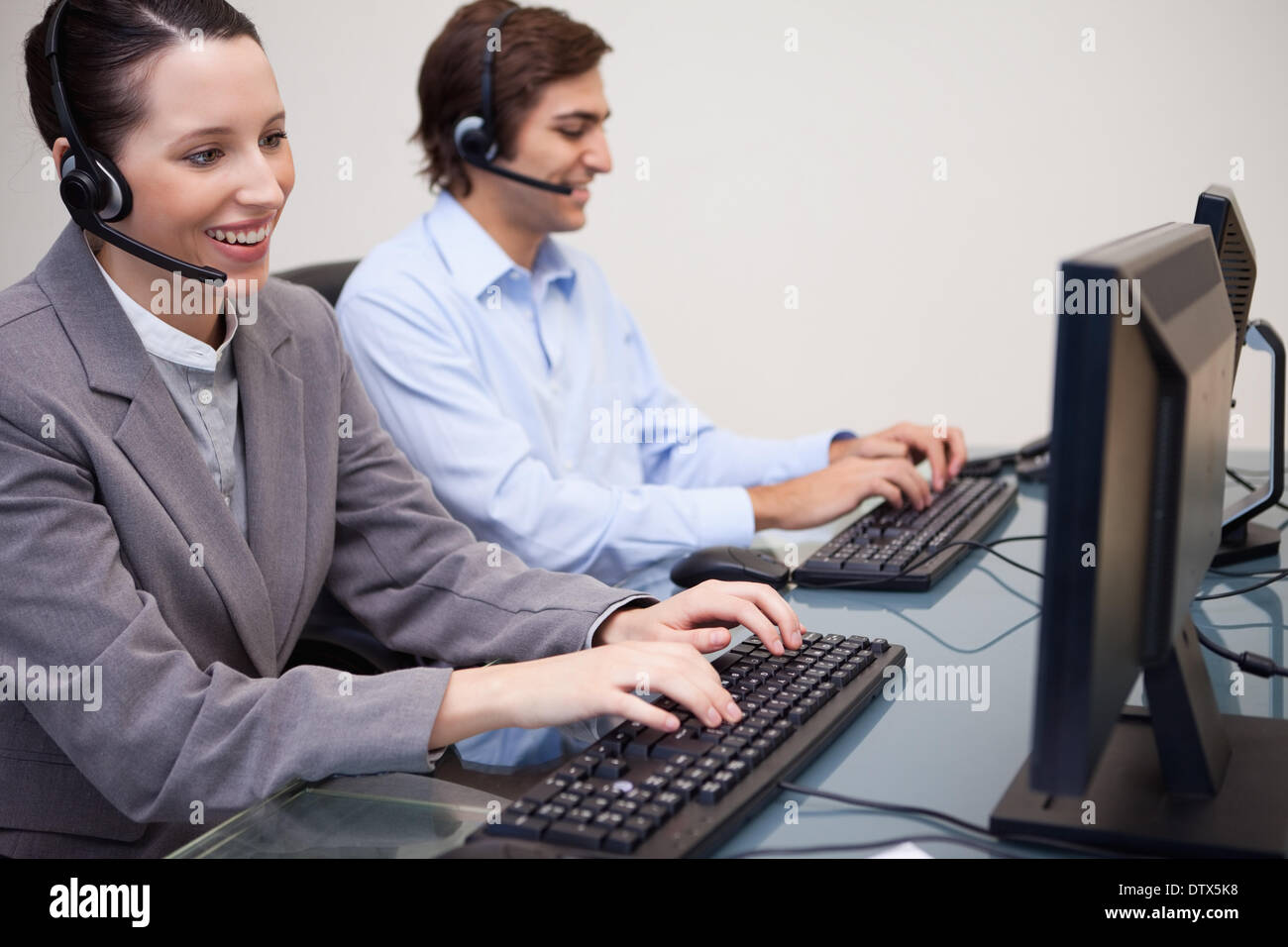 Happy call center employees at work Stock Photo - Alamy