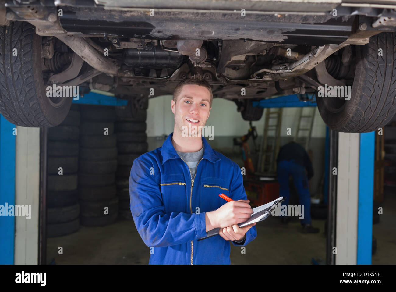 Mechanic preparing checklist under car Stock Photo - Alamy