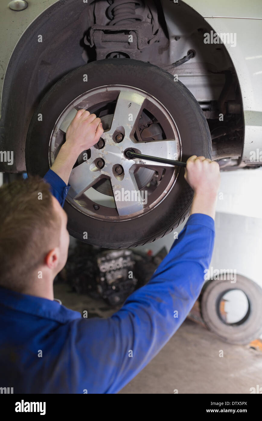 Mechanic fixing car wheel Stock Photo - Alamy
