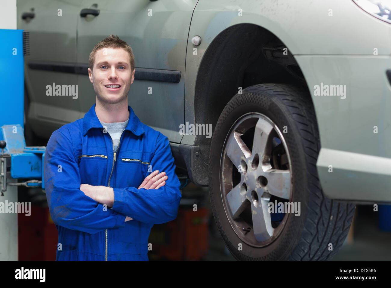 Confident male mechanic standing by car Stock Photo - Alamy