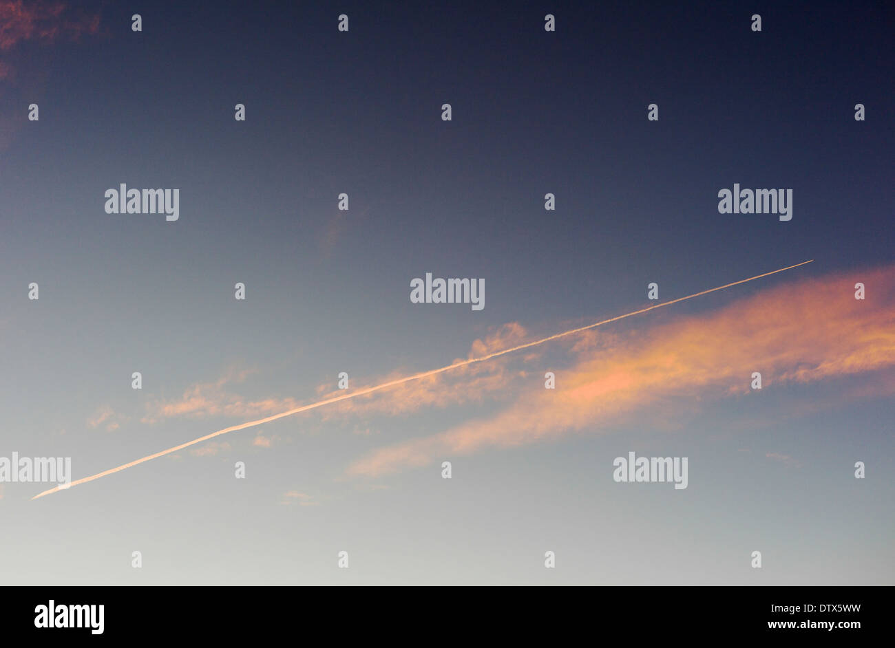 Jet contrails and pink clouds against blue sunset sky in Colorado, USA ...