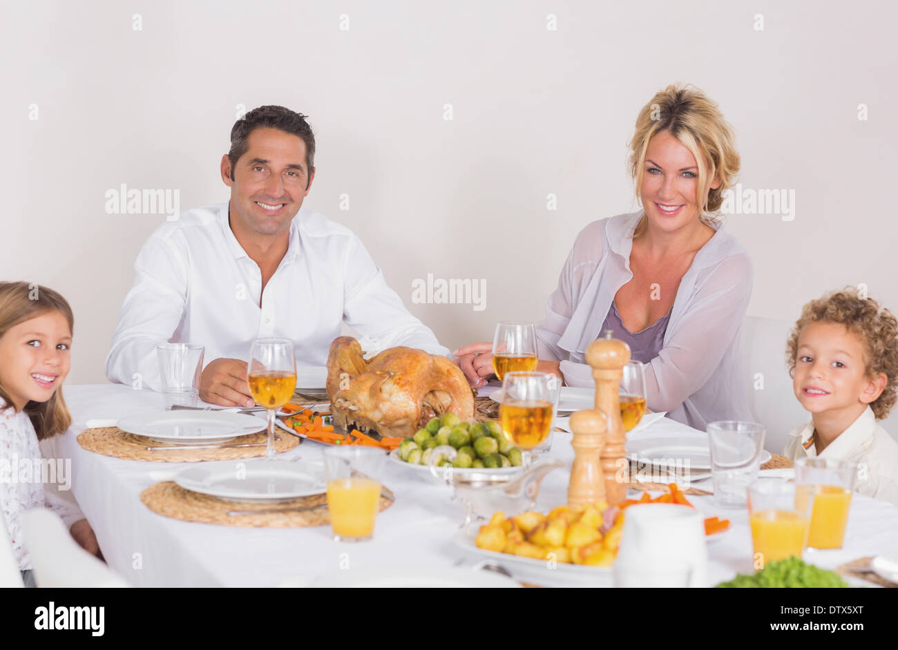 Family sitting on table to eat Stock Photo - Alamy
