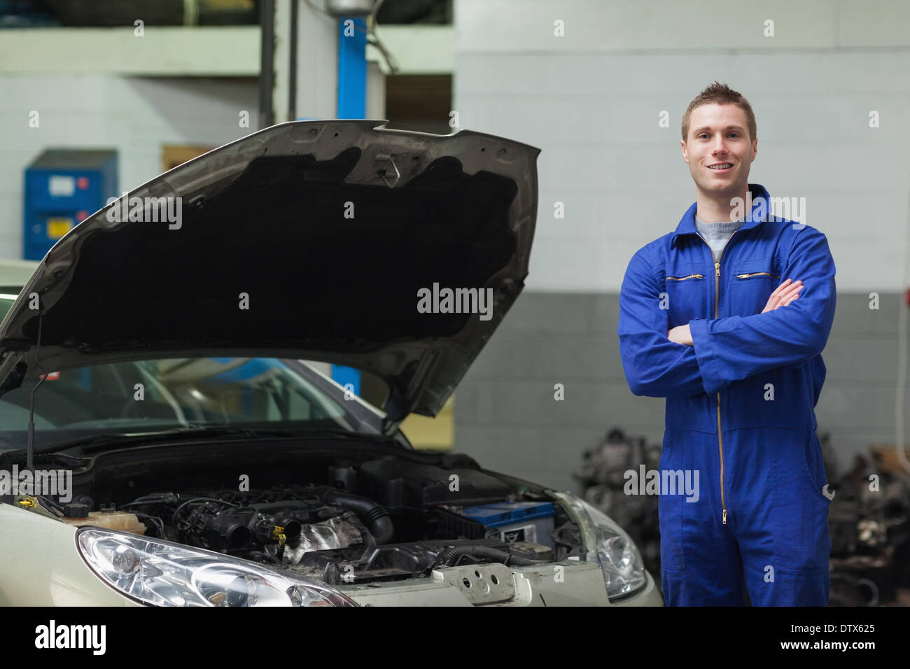 Confident mechanic standing by car Stock Photo - Alamy