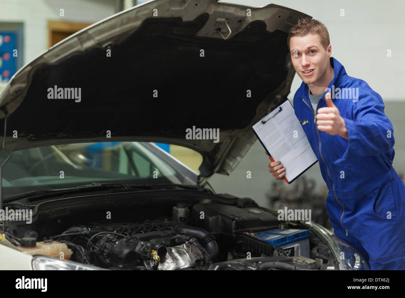 Mechanic with clipboard gesturing thumbs up Stock Photo - Alamy