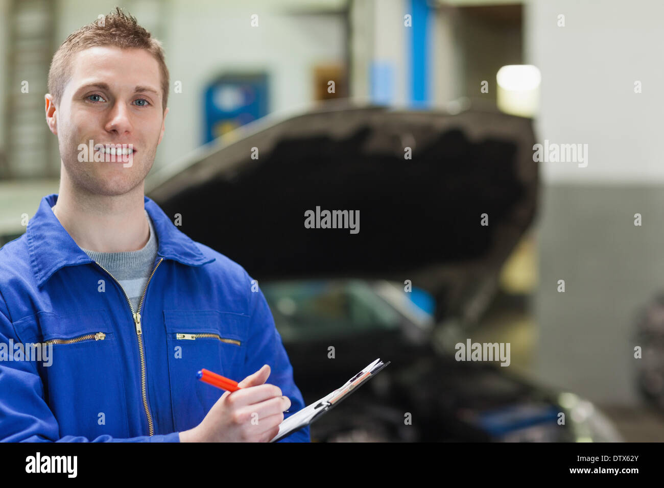 Happy mechanic with clipboard Stock Photo - Alamy