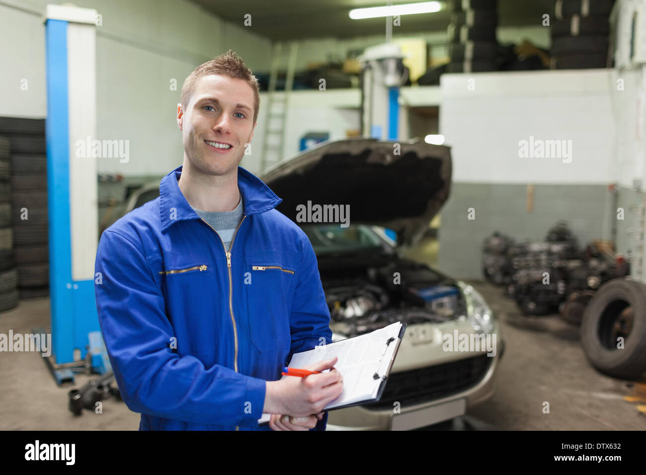Mechanic writing on clipboard Stock Photo - Alamy