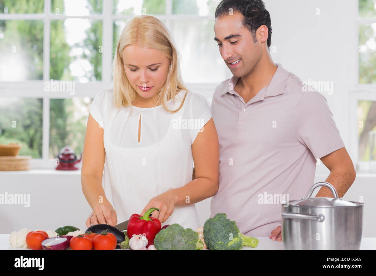 Husband looking at his wife cooking Stock Photo - Alamy