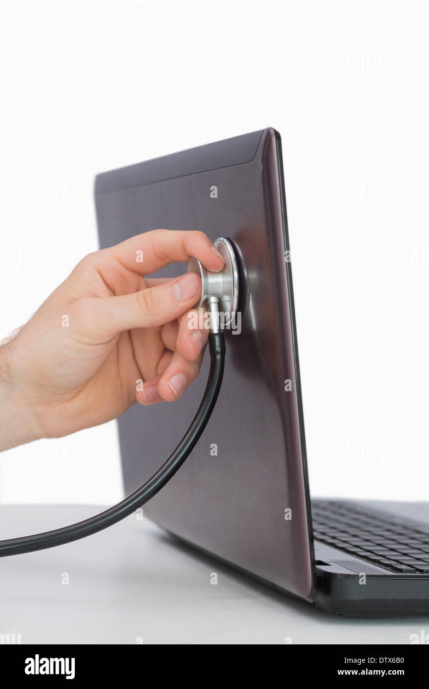 Hand examining laptop with stethoscope Stock Photo - Alamy