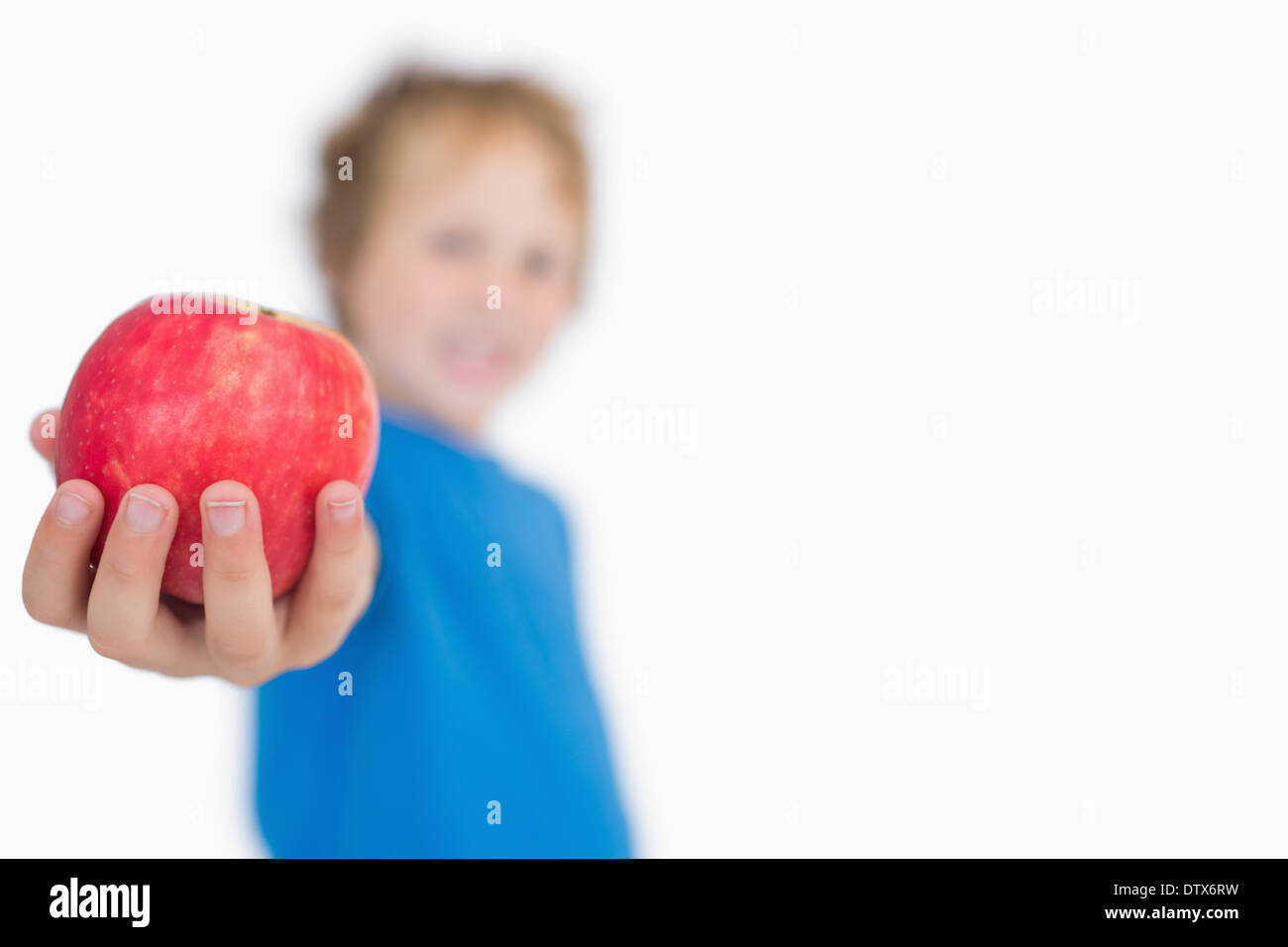 Young boy holding out a apple Stock Photo - Alamy