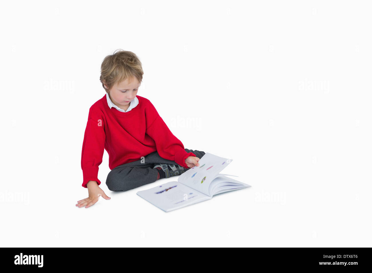 Little boy sitting and reading book Stock Photo - Alamy