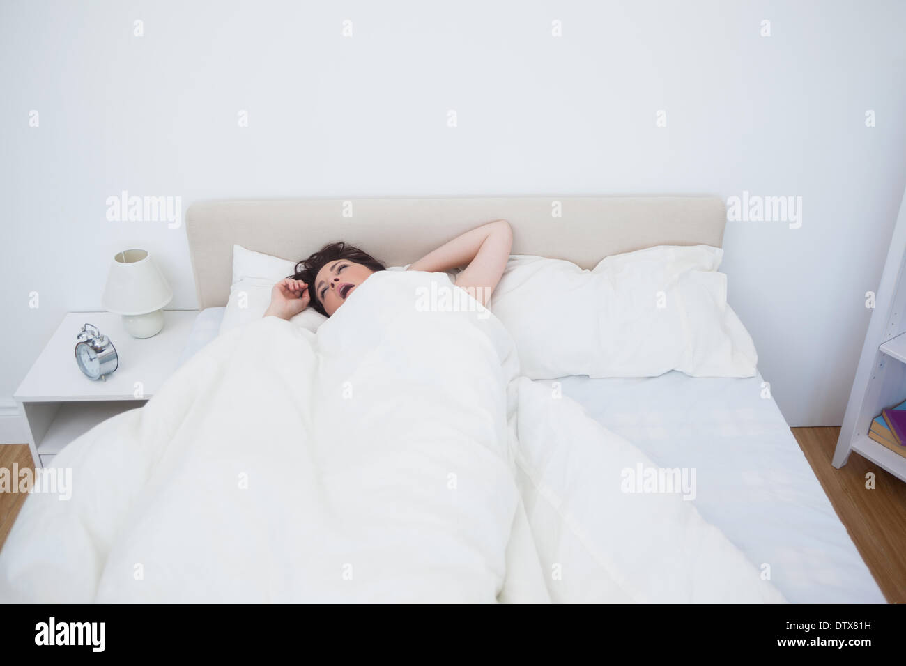 Woman yawning in bed Stock Photo - Alamy