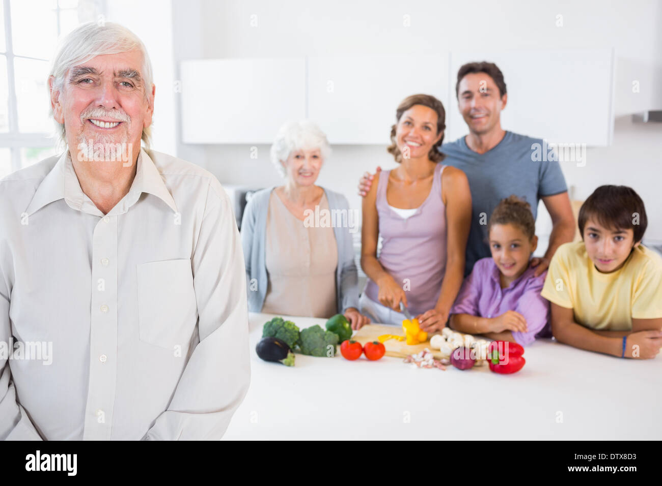 Happy grandfather standing by kitchen counter Stock Photo - Alamy