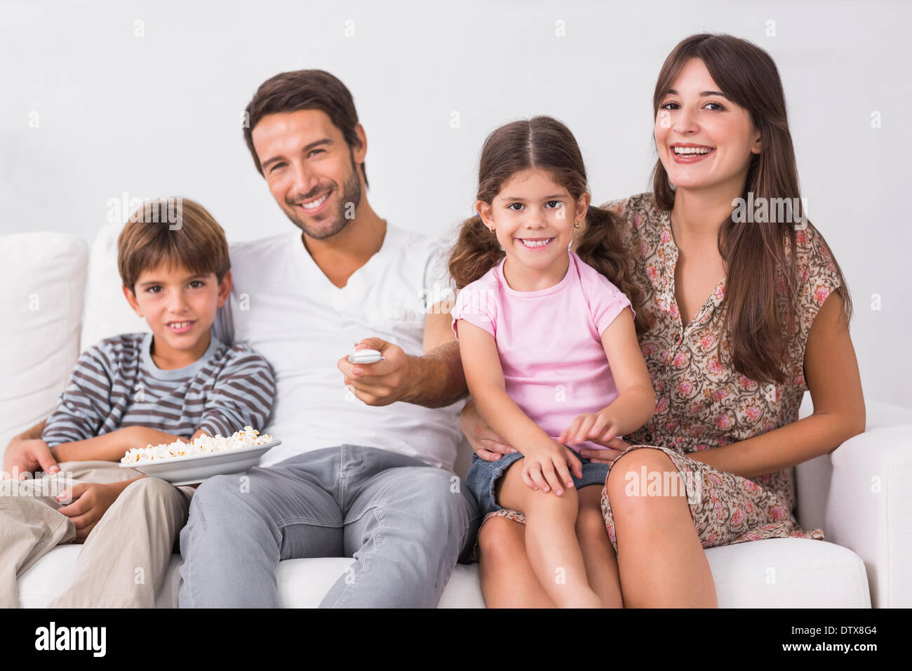 Smiling family watching the television Stock Photo - Alamy