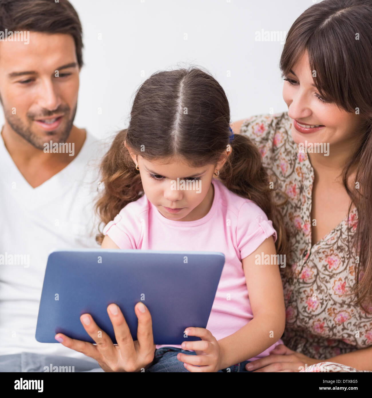 Parents watching daughter using tablet pc Stock Photo - Alamy