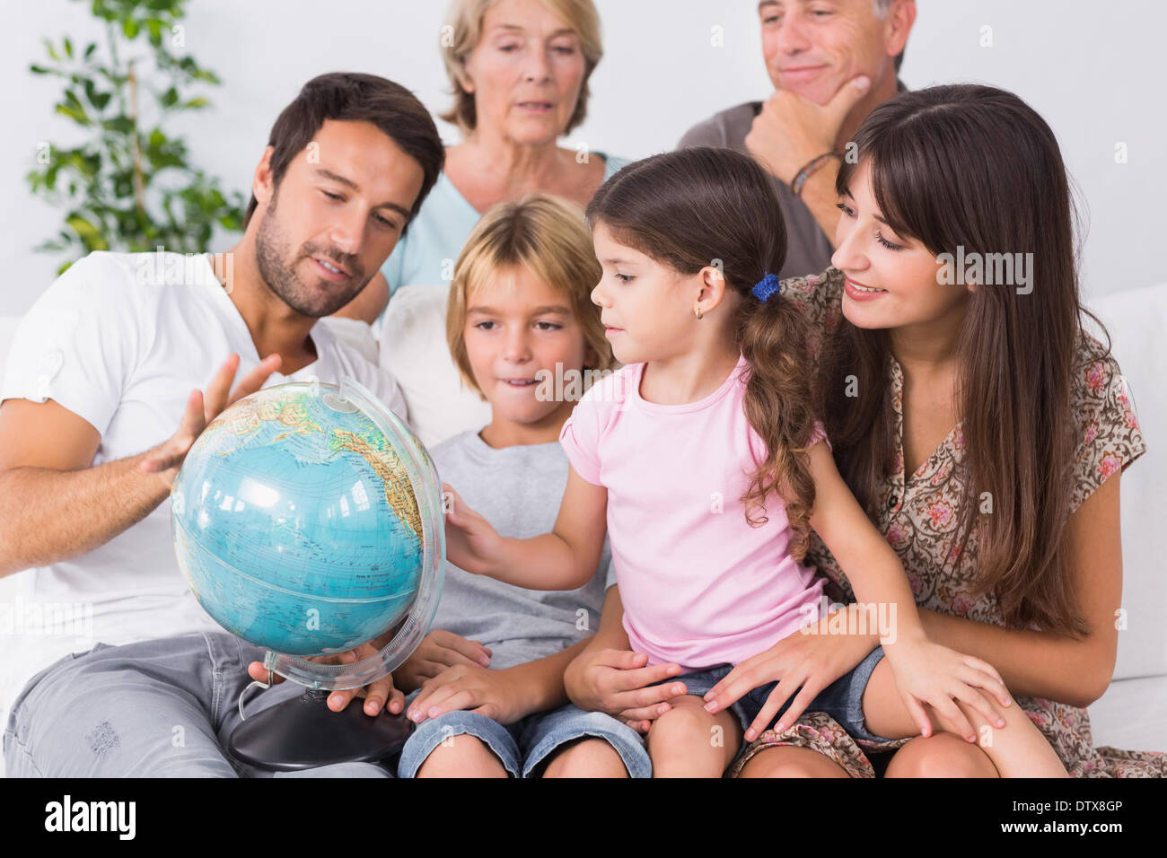 Happy family looking at globe Stock Photo - Alamy
