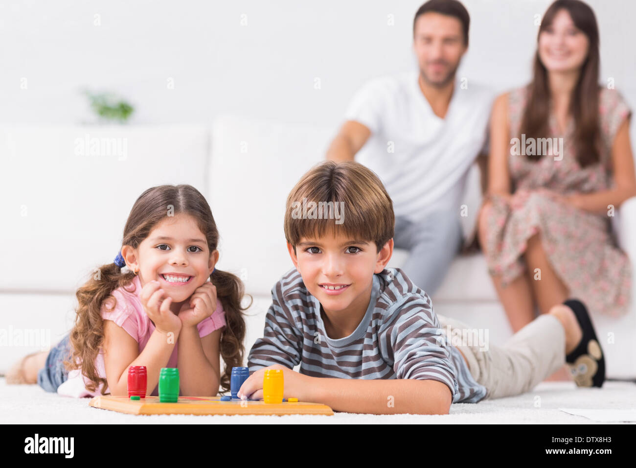 Happy siblings playing board game on floor Stock Photo - Alamy
