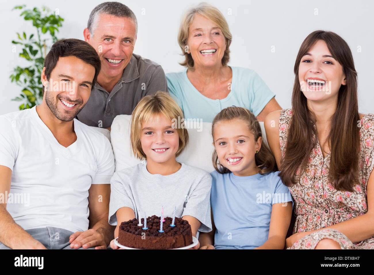 Smiling family with birthday cake Stock Photo - Alamy