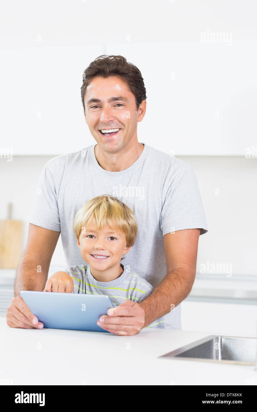 Laughing father and son using tablet Stock Photo - Alamy