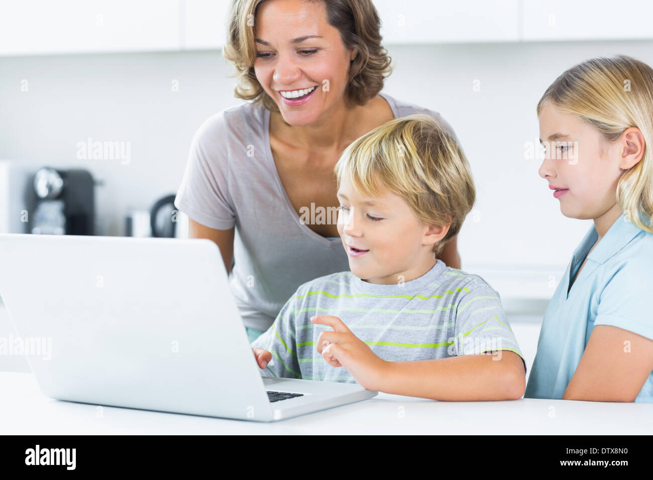 Mother using laptop with her children Stock Photo - Alamy