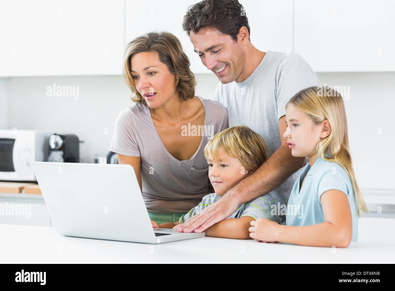 Happy family using laptop Stock Photo - Alamy