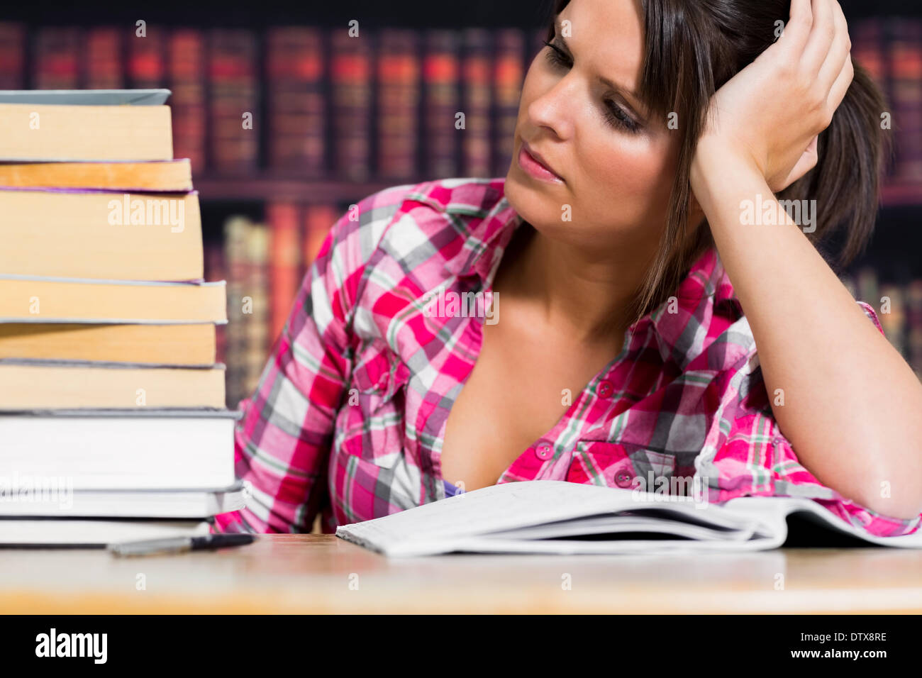 Woman thinking in the library Stock Photo - Alamy